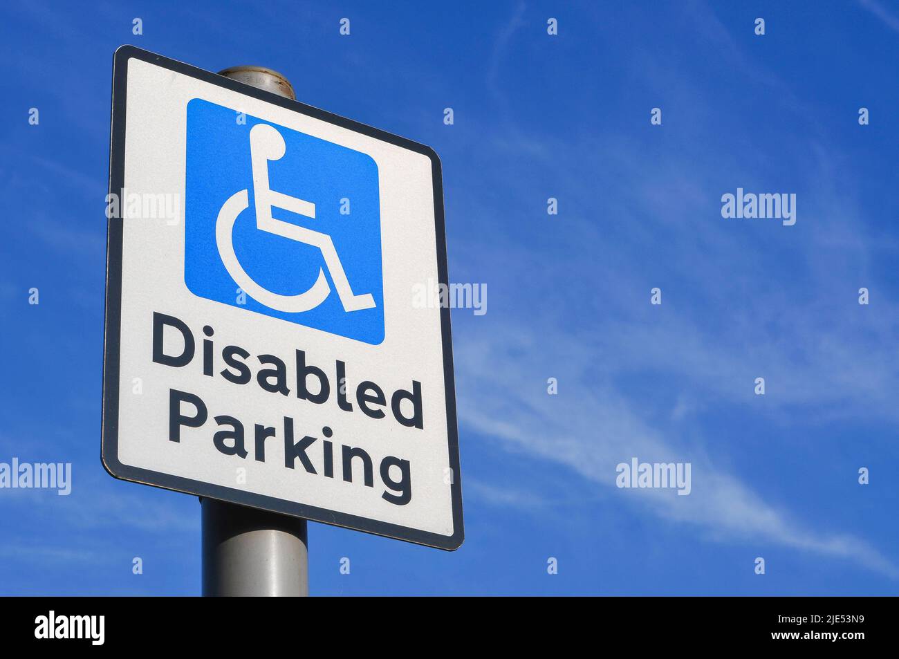 Disabled parking space sign against a clear blue sky Stock Photo - Alamy