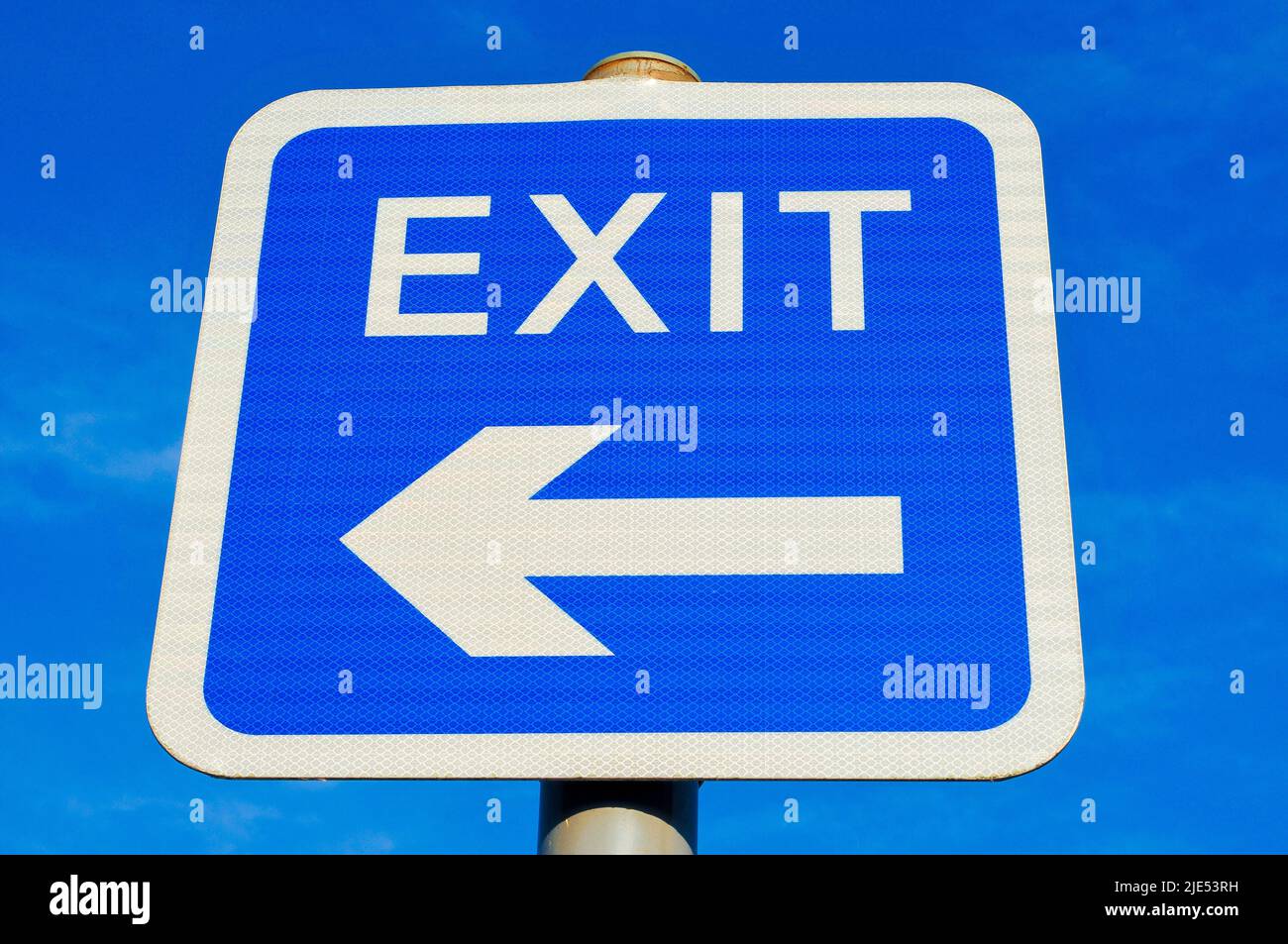 Low angle view of blue and white EXIT road sign with directional arrow ...