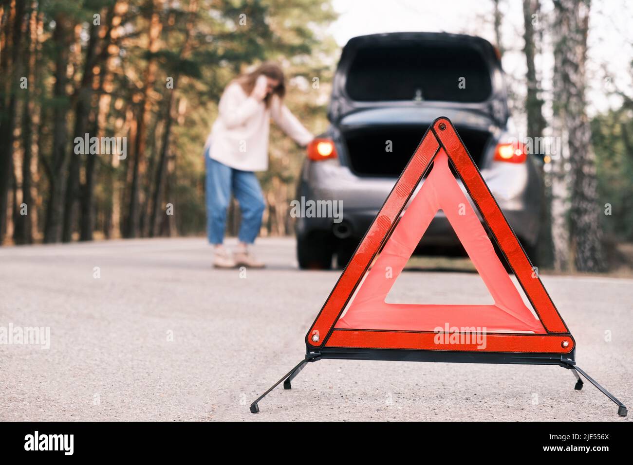 Close up on triangle warning sign with woman calling for assistance ...