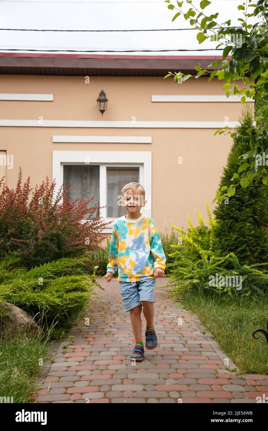 A boy of European appearance walks merrily.A five-year-old boy is ...