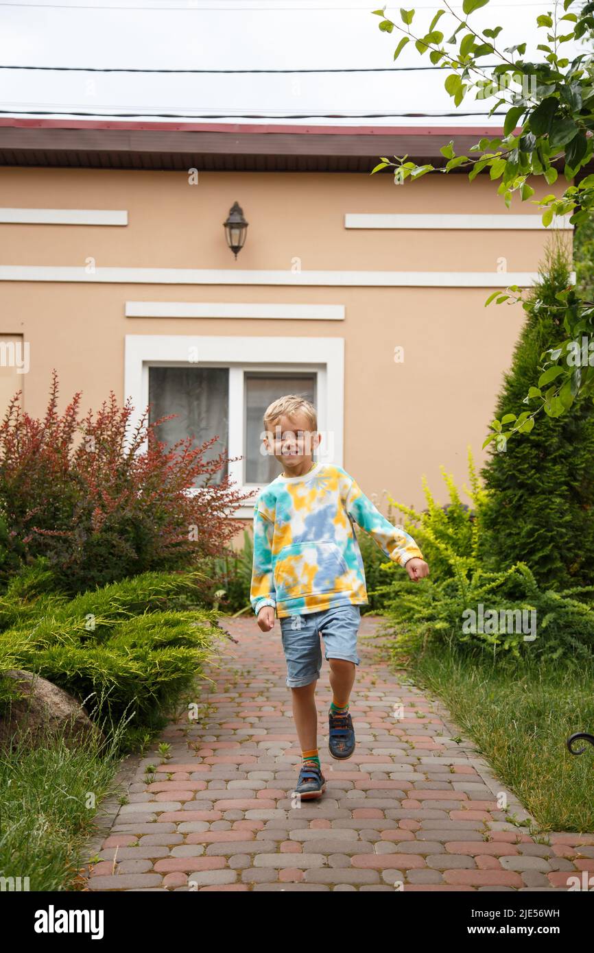 A boy of European appearance walks merrily.A five-year-old boy is ...