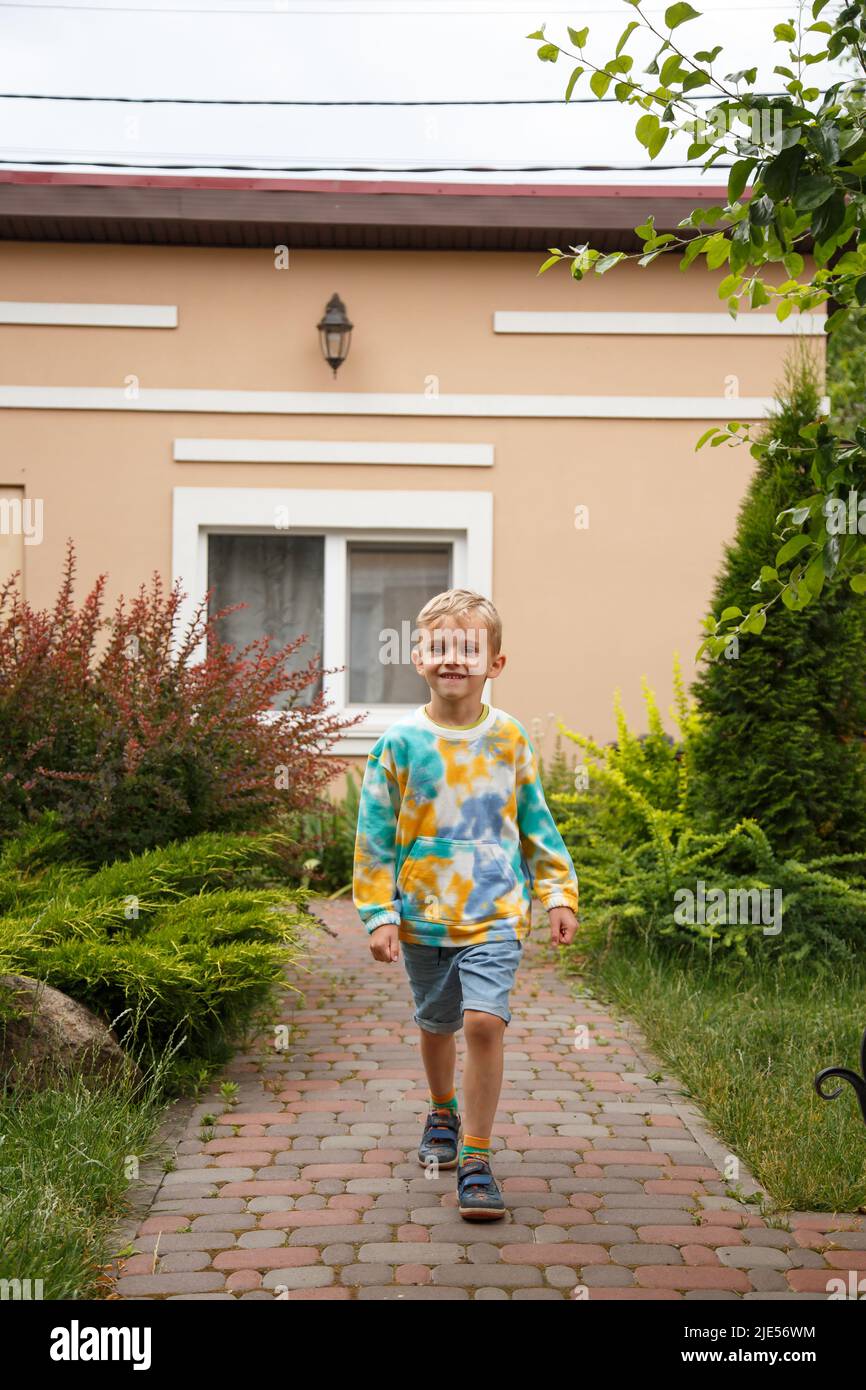 A boy of European appearance walks merrily.A five-year-old boy is ...