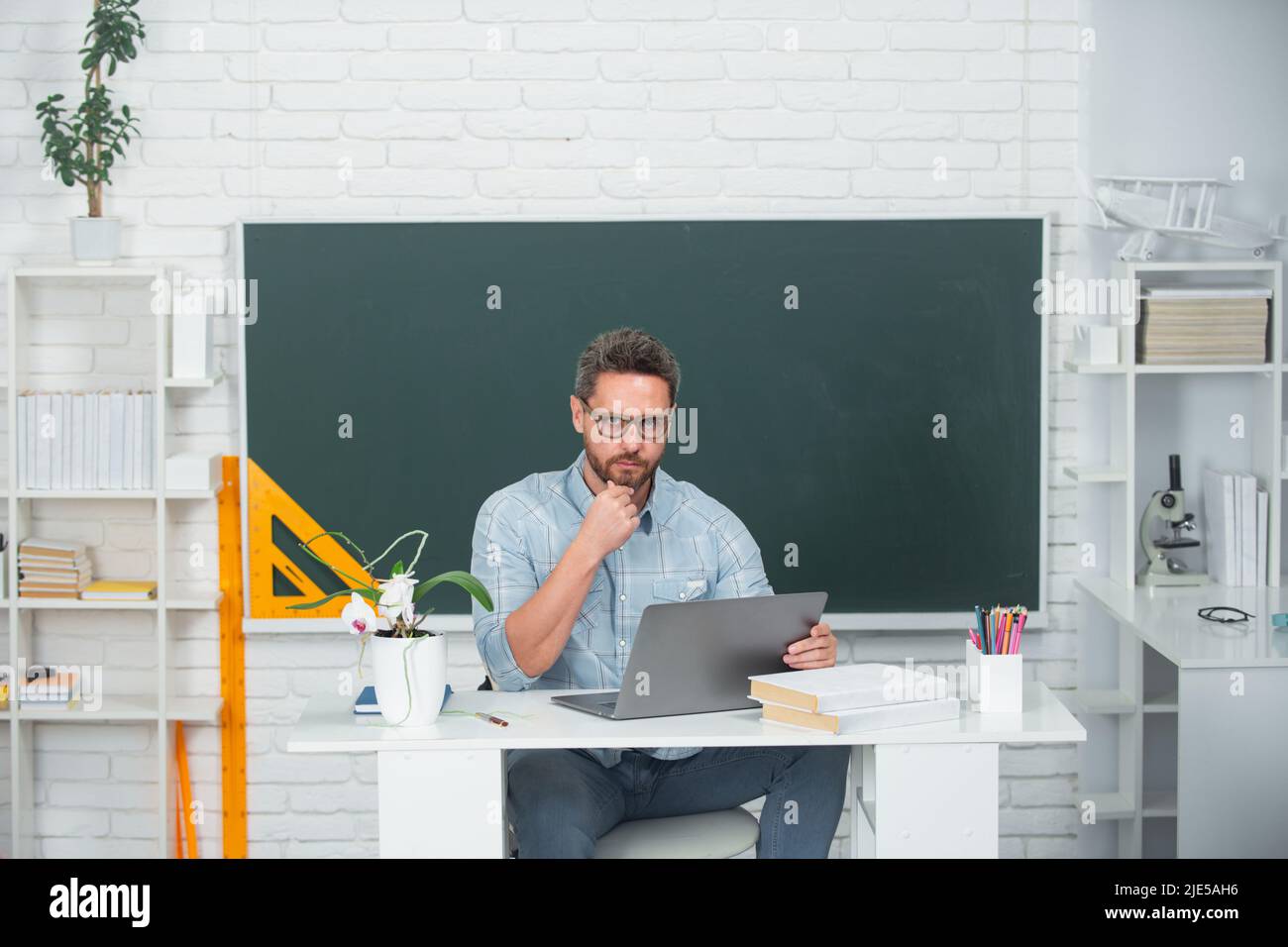 Portrait of male teacher teaching line of high school students with ...