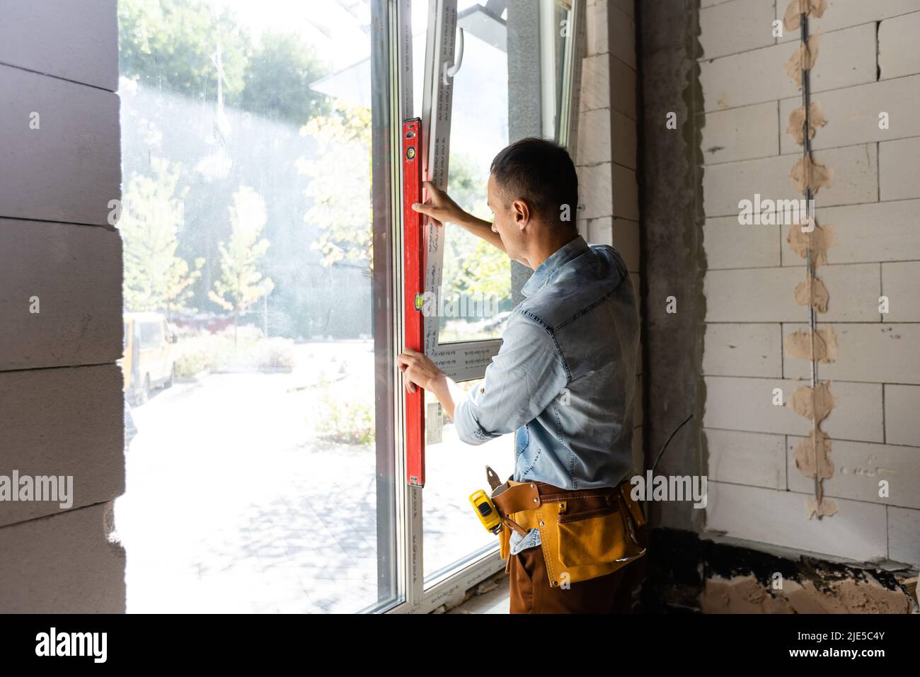 Construction worker installing window in house Stock Photo - Alamy