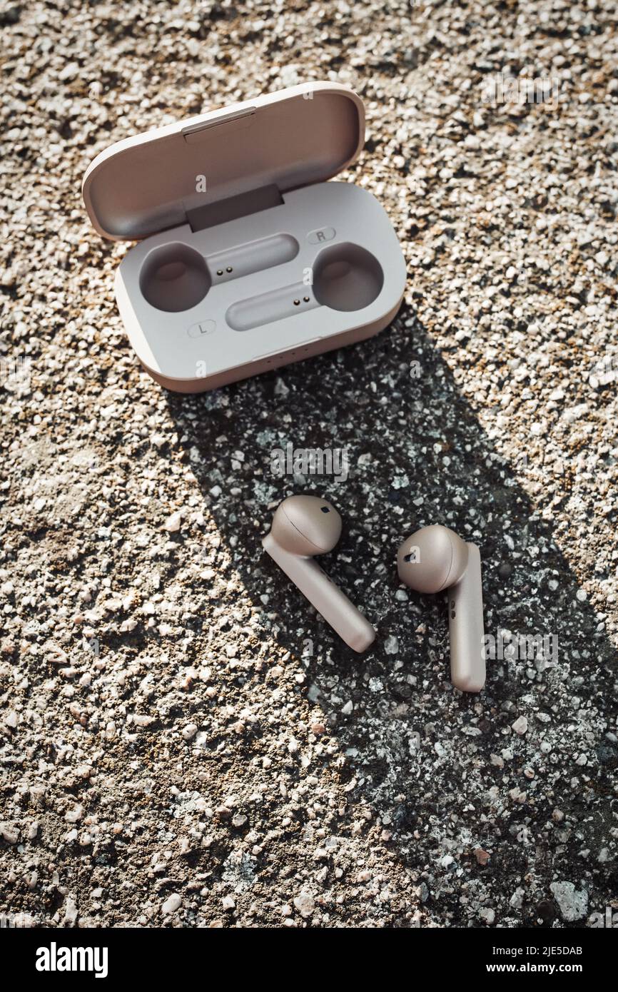 True wireless earbuds in case on natural stone background Stock Photo ...