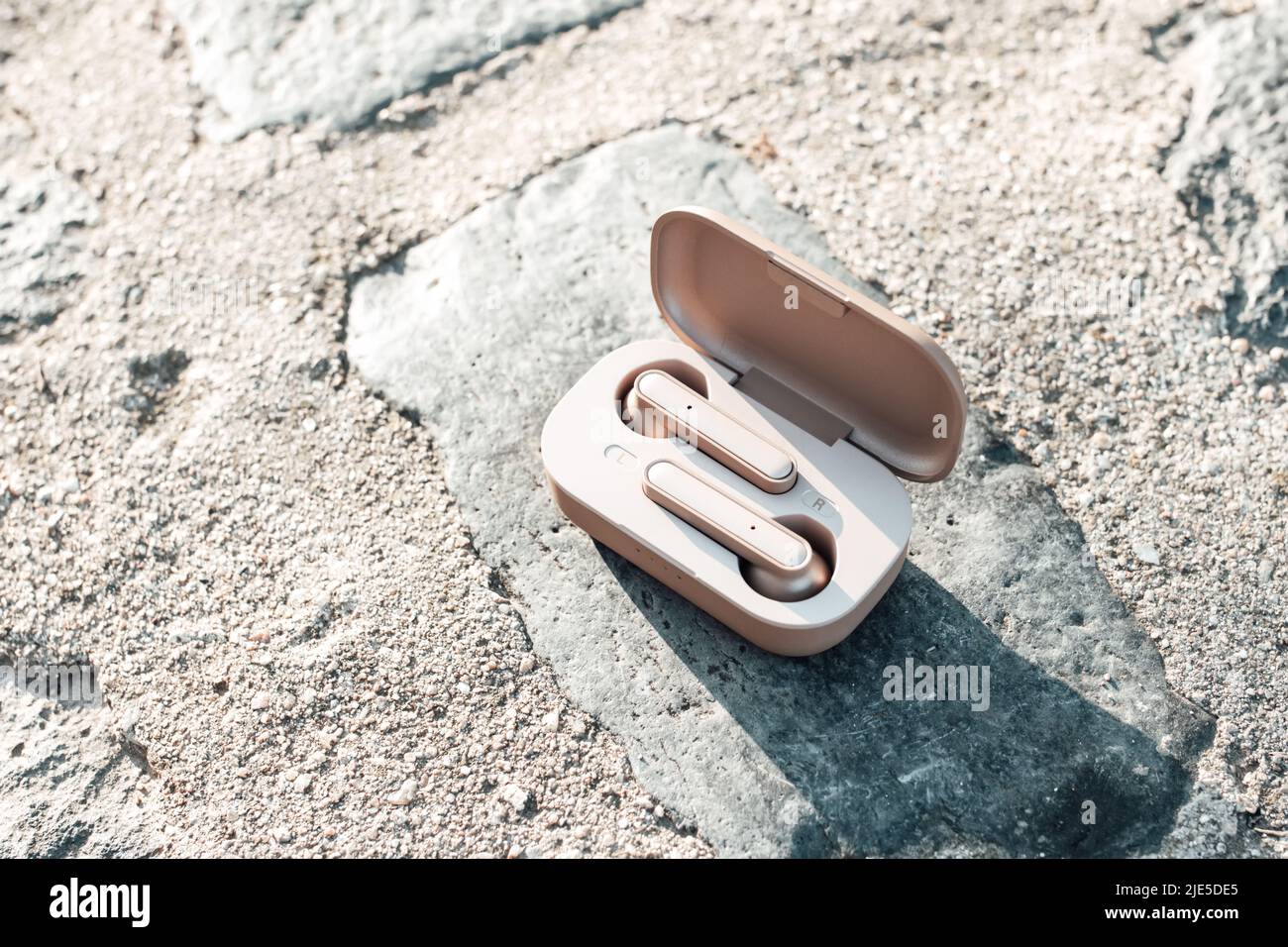 True wireless earbuds in case on natural stone background Stock Photo ...