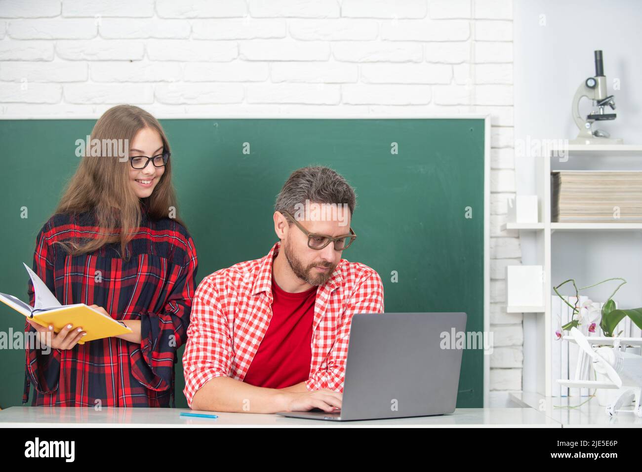 Teacher explains lesson to school child. Elementary school kids ...