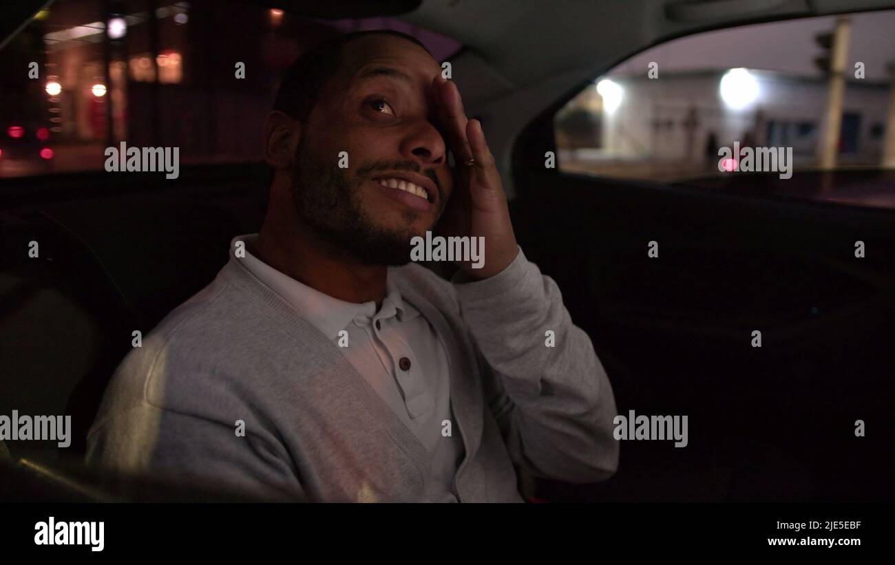 Happy passenger inside taxi cab in backseat vehicle at night. One happy ...