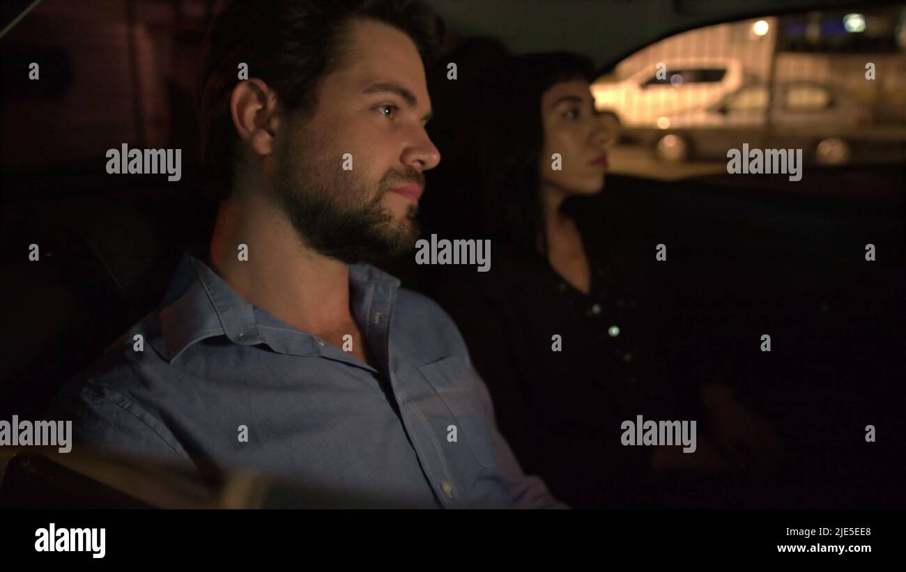 People inside car backseat at night. Man and woman riding taxi cab ...