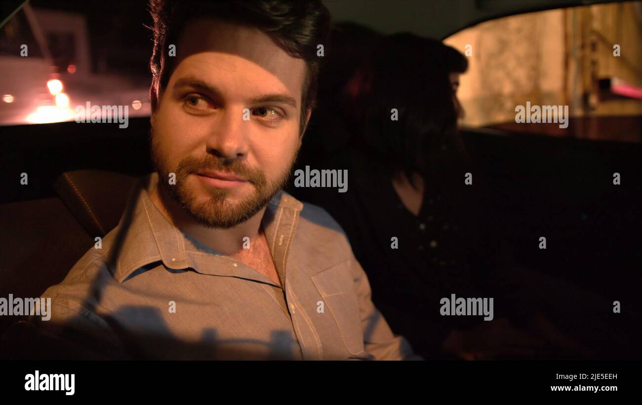 People inside car backseat at night. Man and woman riding taxi cab ...