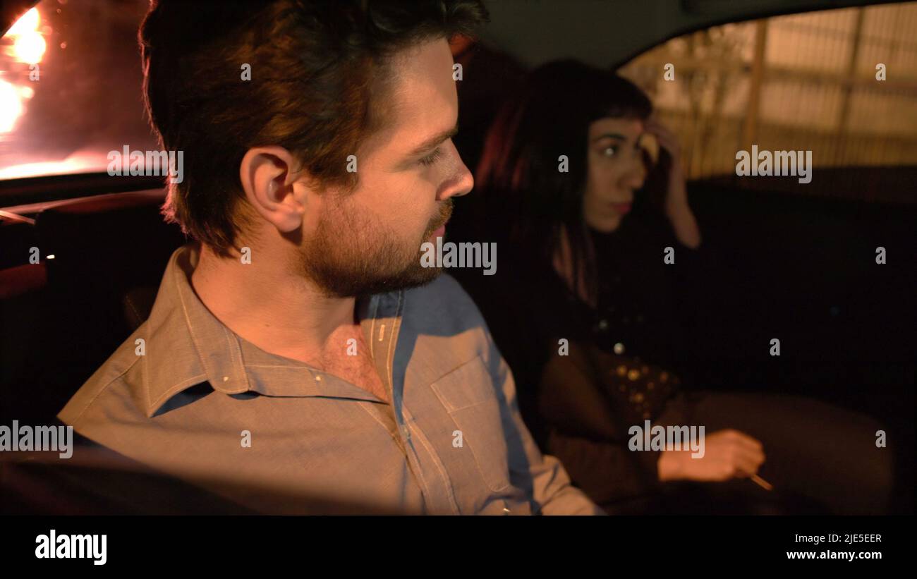 People inside car backseat at night. Man and woman riding taxi cab ...