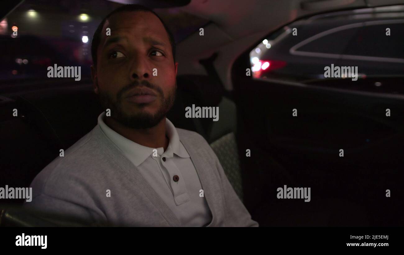 One stressed black man sitting in car backseat stuck in traffic ...