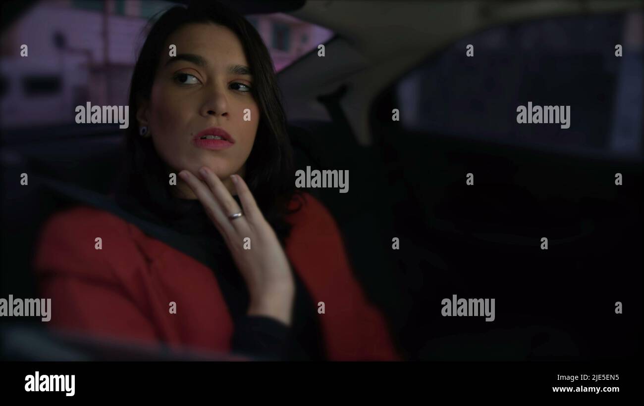 One anxious person stuck in traffic in car backseat. Young woman ...