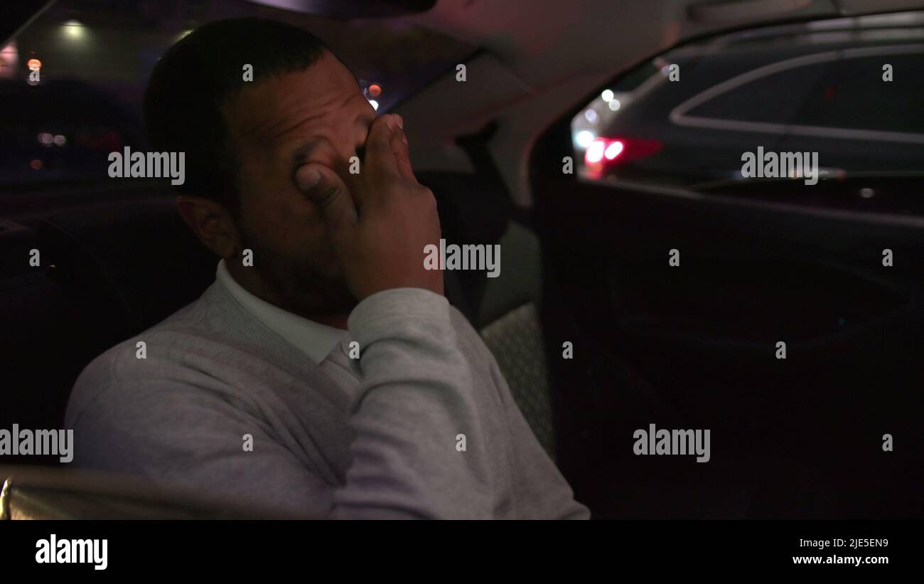 One stressed black man sitting in car backseat stuck in traffic ...