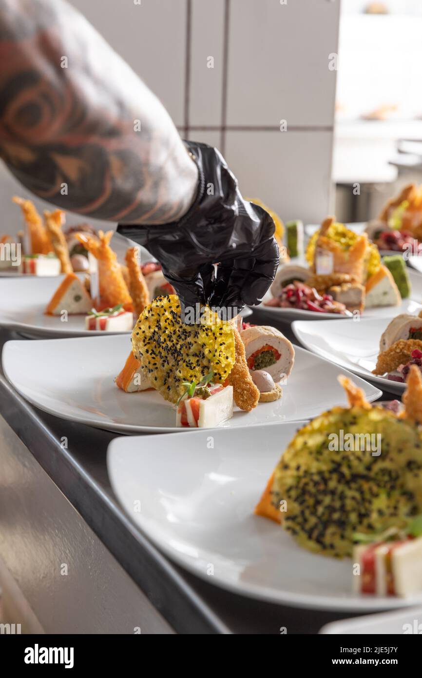 Chef is in process of preparing catering food table for a party on a ...
