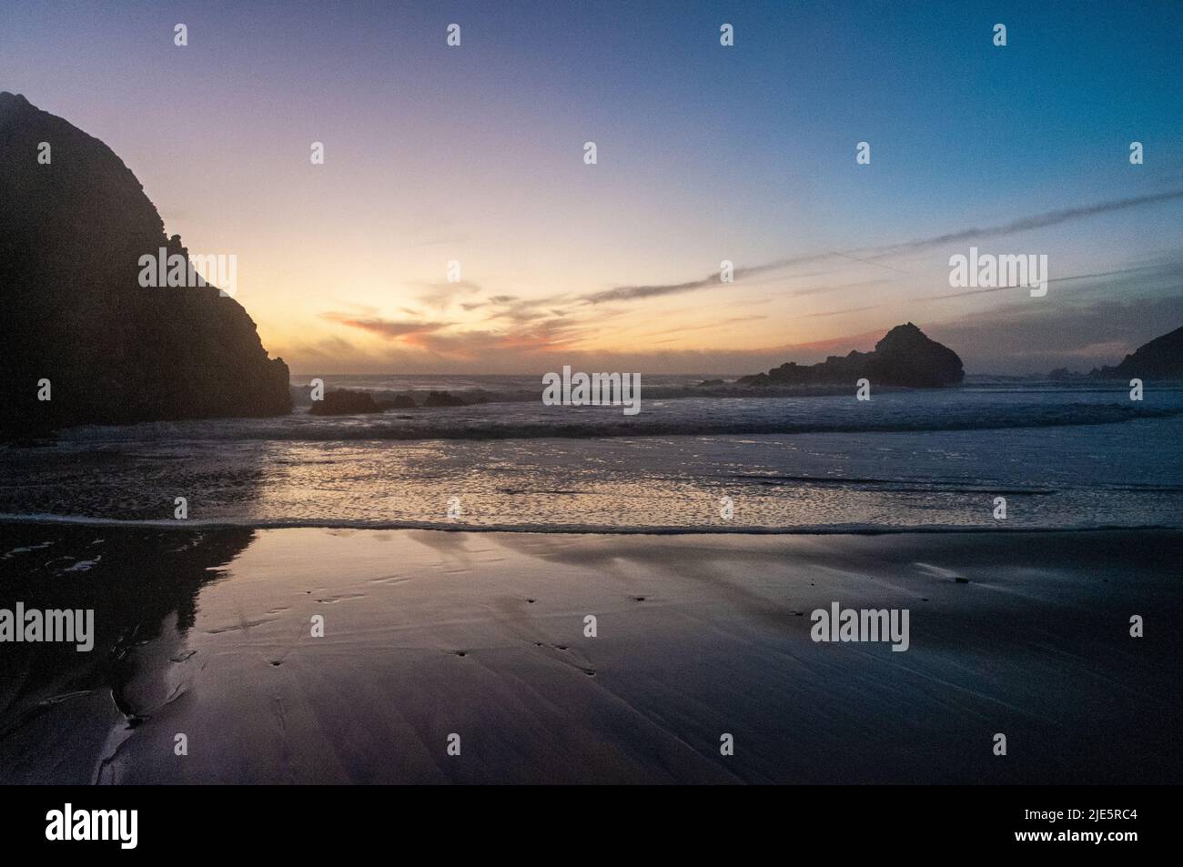 Rocks in the surf of Pfeiffer beach, around sunset. Deep yellow orange ...