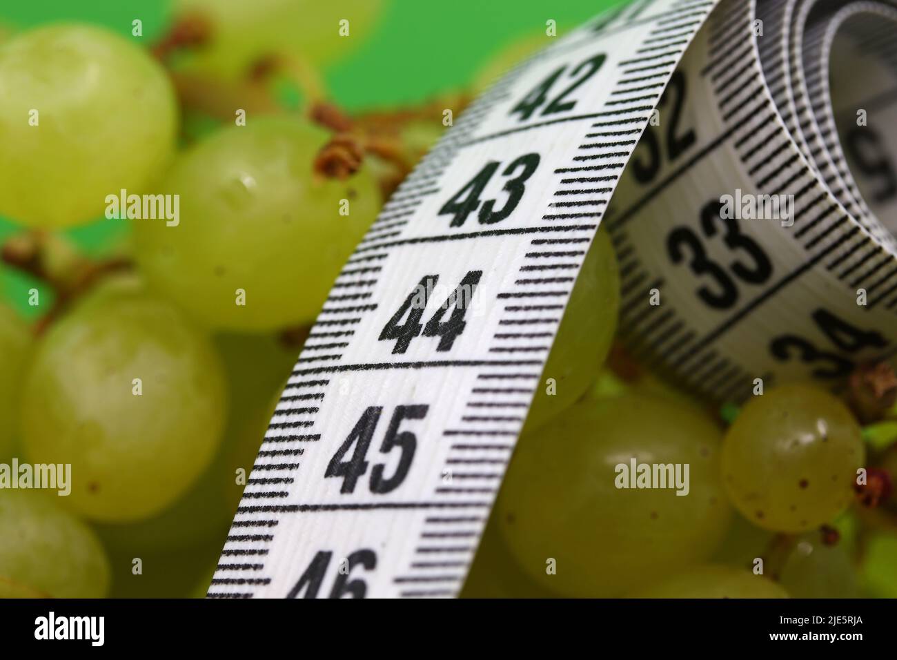 Close-up green grape with white measuring tape Stock Photo - Alamy