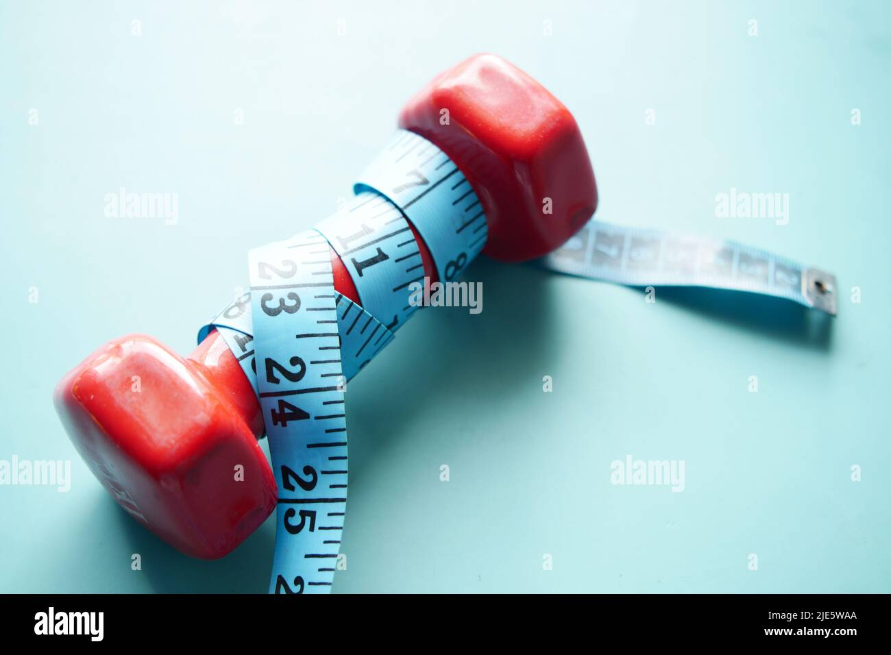 Fitness concept with dumbbell and measurement tape Stock Photo - Alamy