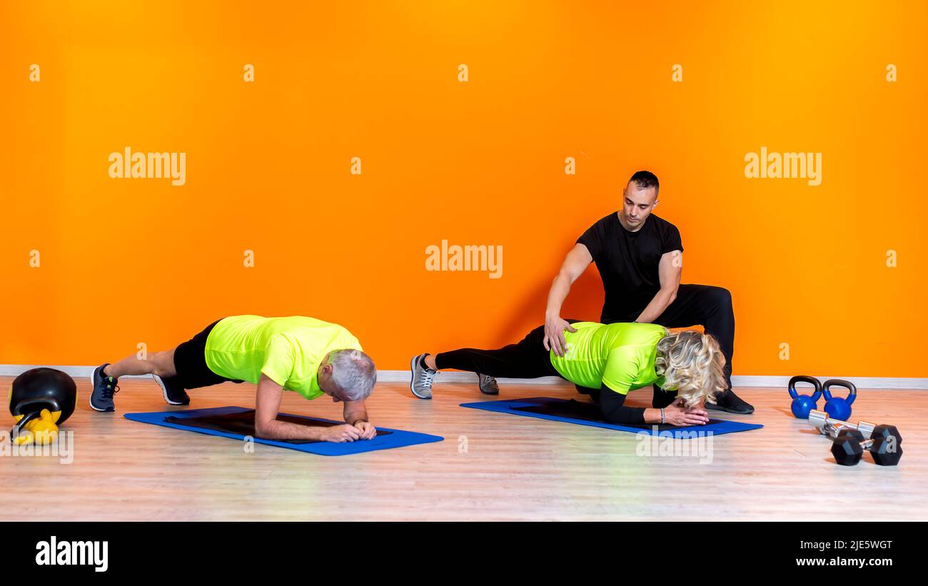 senior fit couple doing push up workout exercise laying at the gym ...