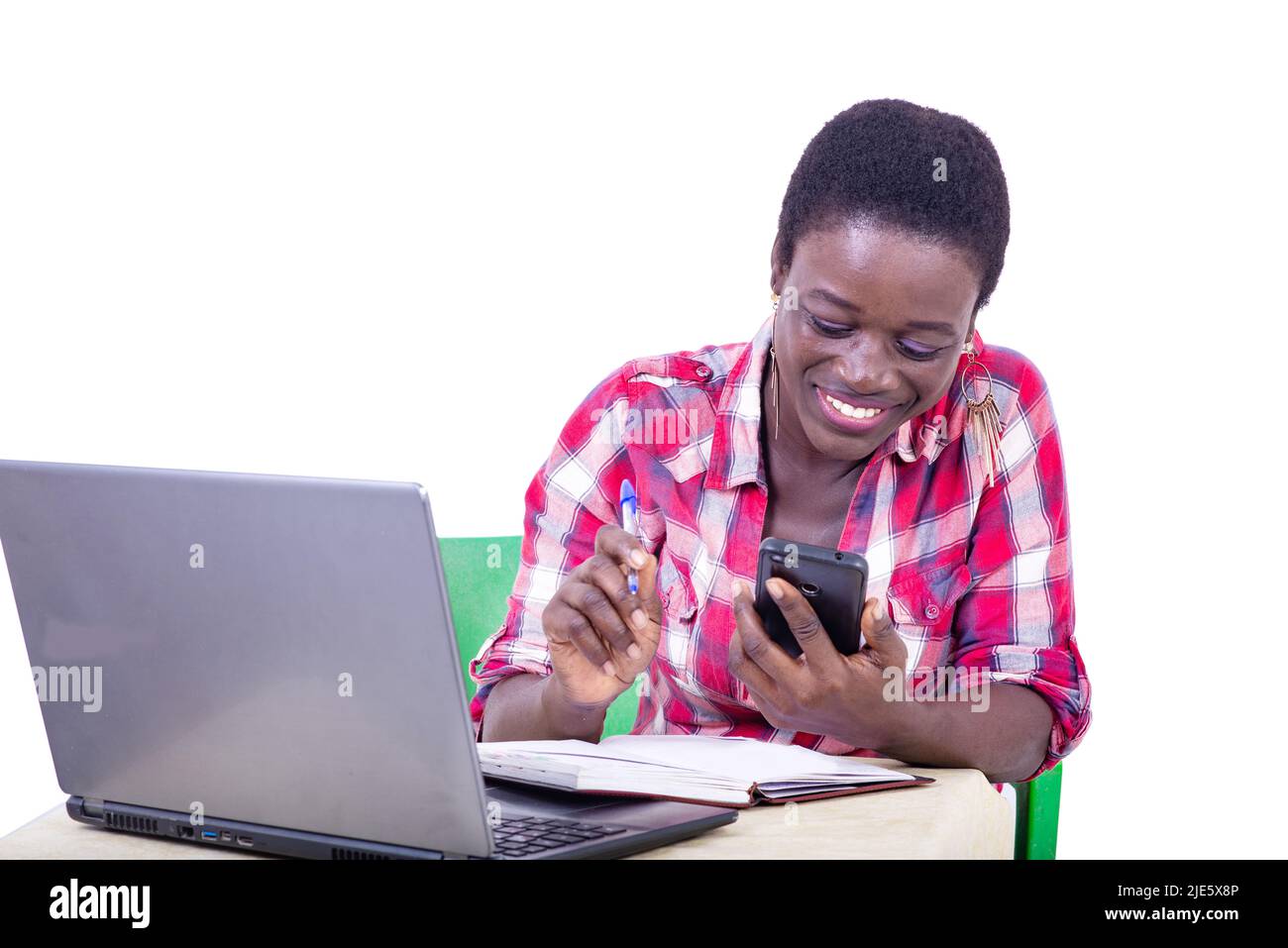 beautiful young businesswoman sitting in front of a laptop, writing in ...