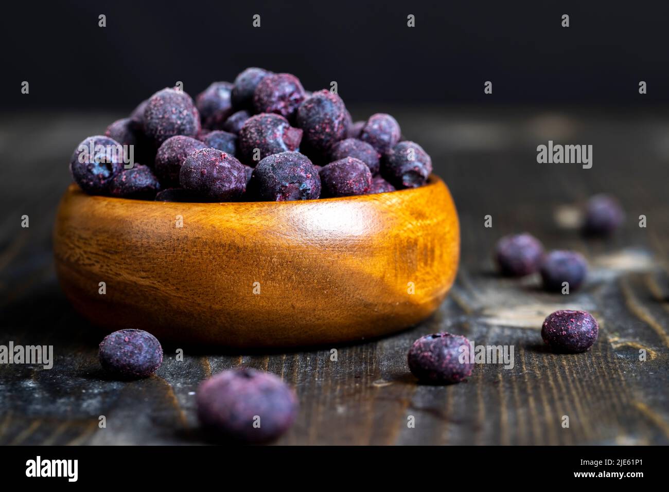 frozen blueberries on a wooden table, ripe deep-frozen blueberries on a ...