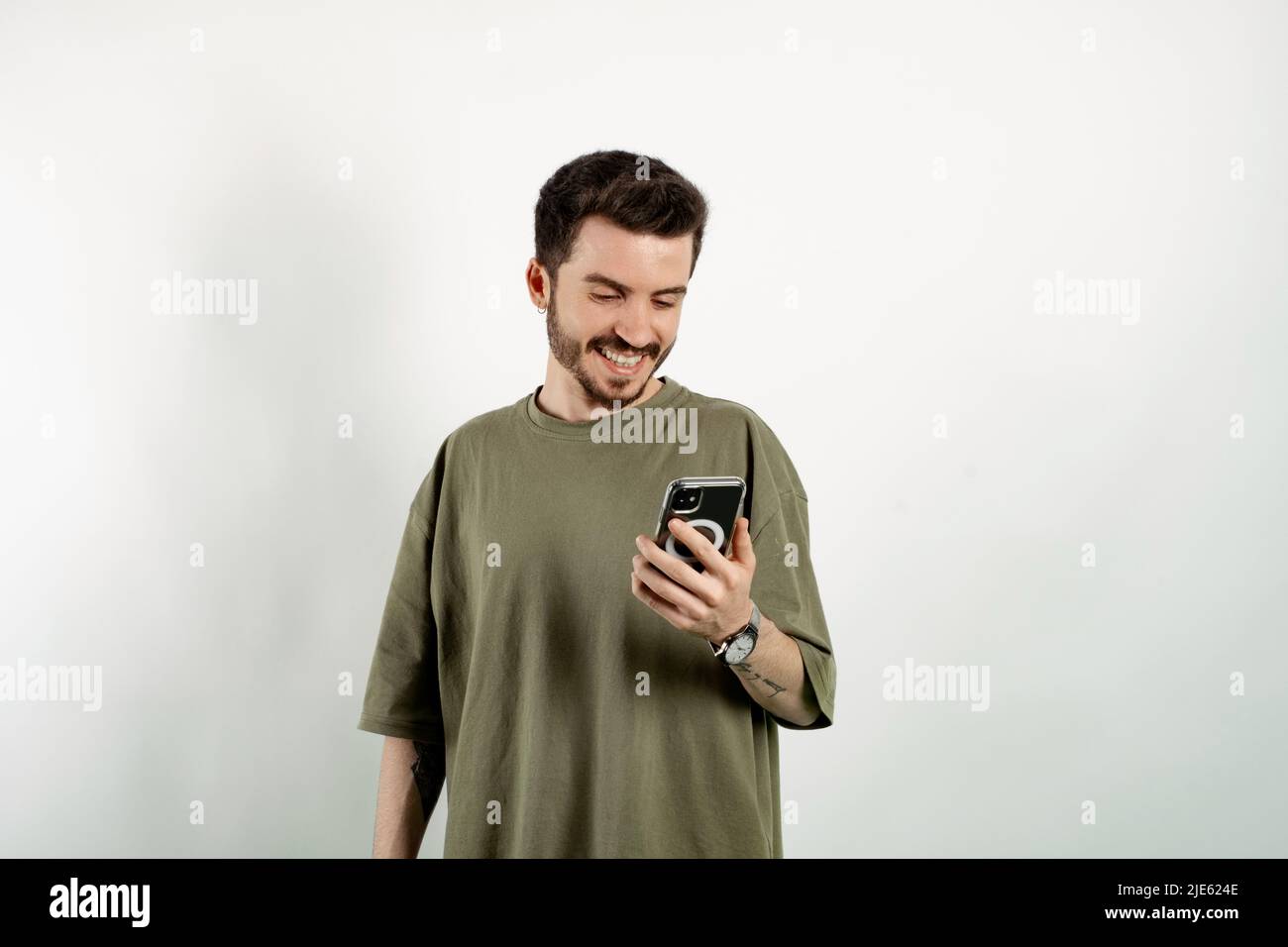 Cheerful young man wearing t-shirt posing isolated over white ...