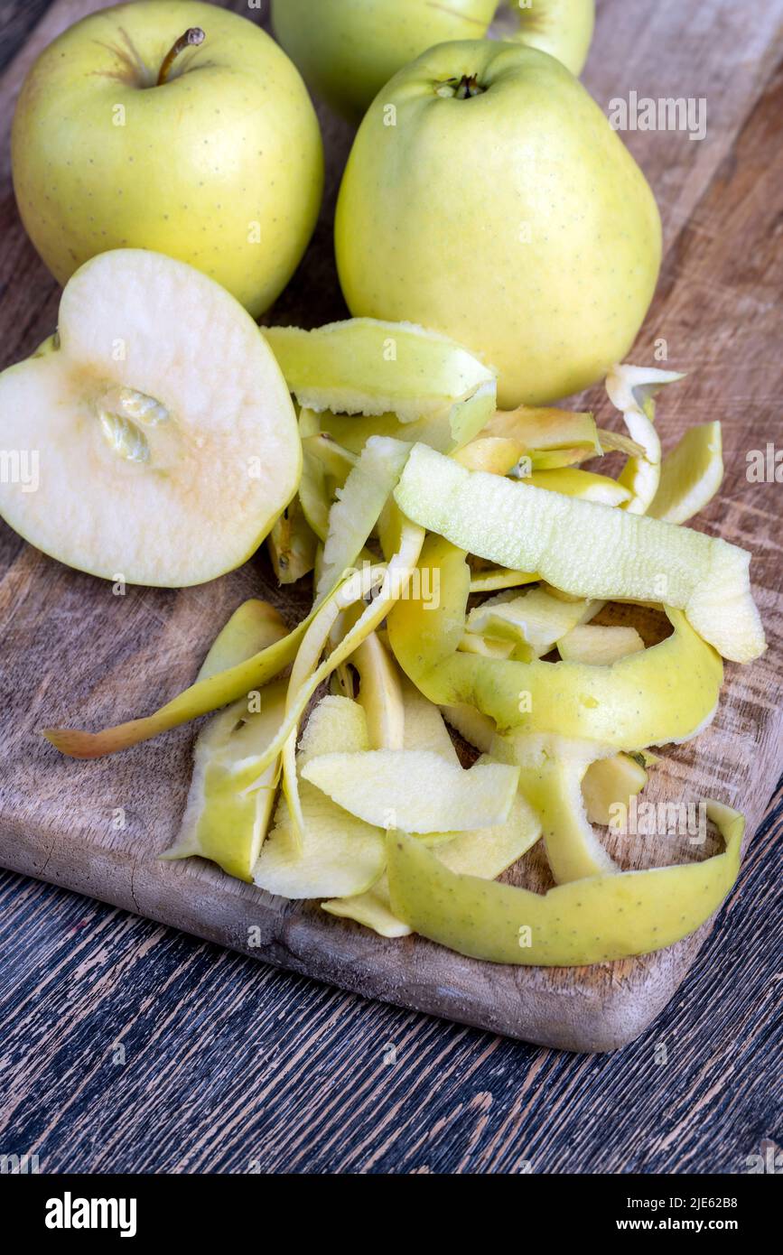 sliced and peeled green apple on a wooden board, ripe apple while ...