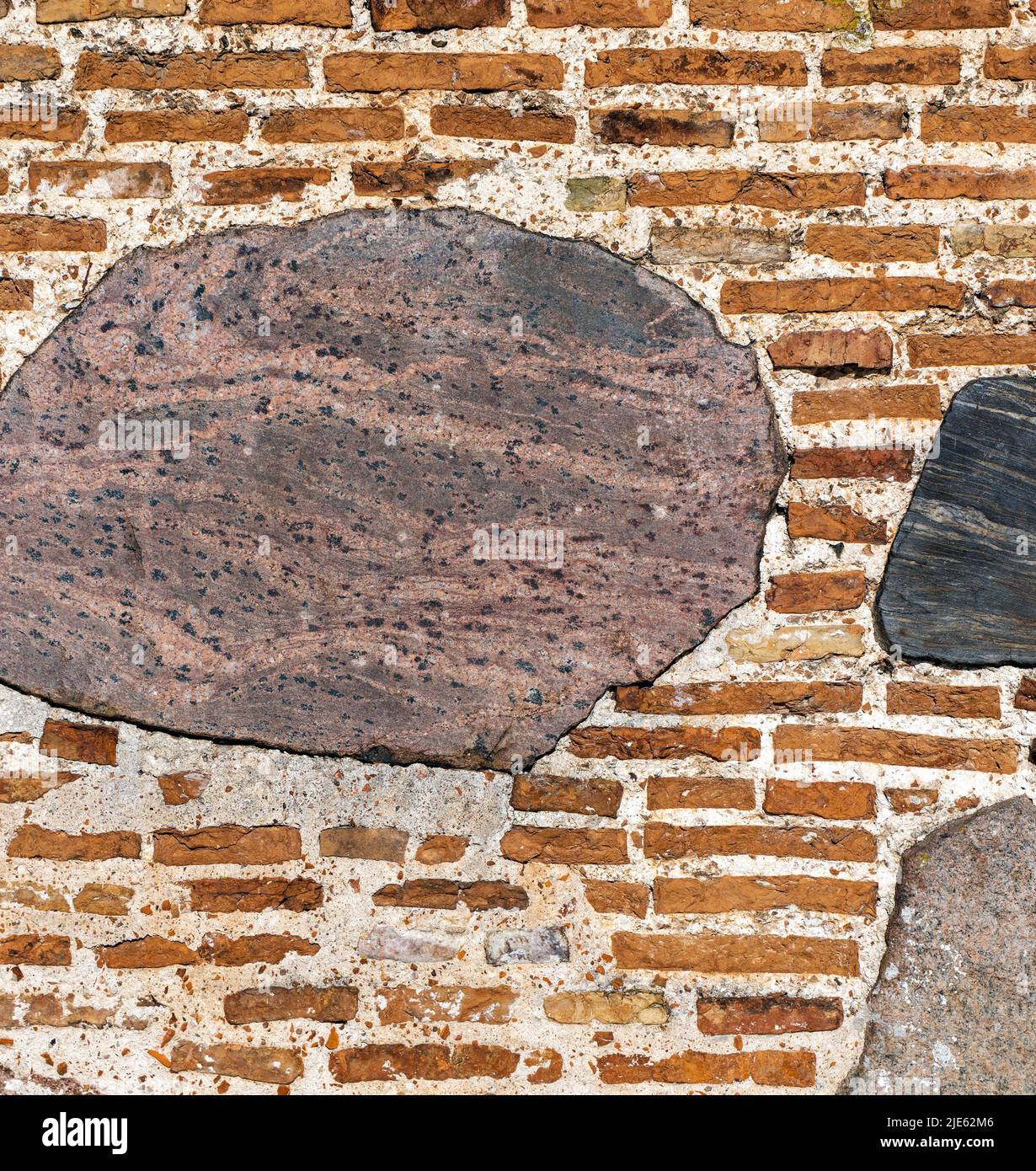 stone brick wall of an old building, part of an old wall made of clay ...