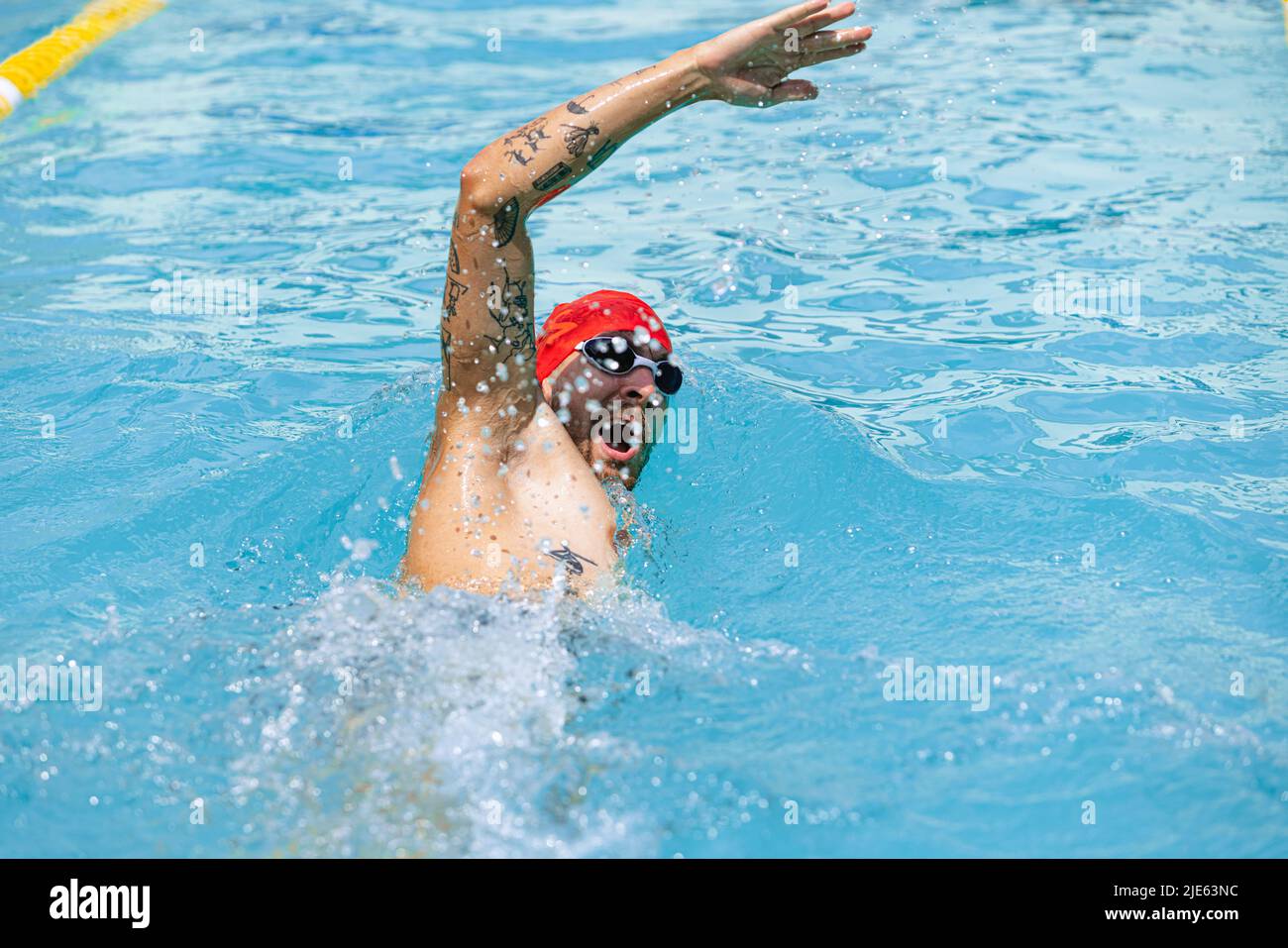 One athlete, male professional swimmer in goggles and red swimming cap ...