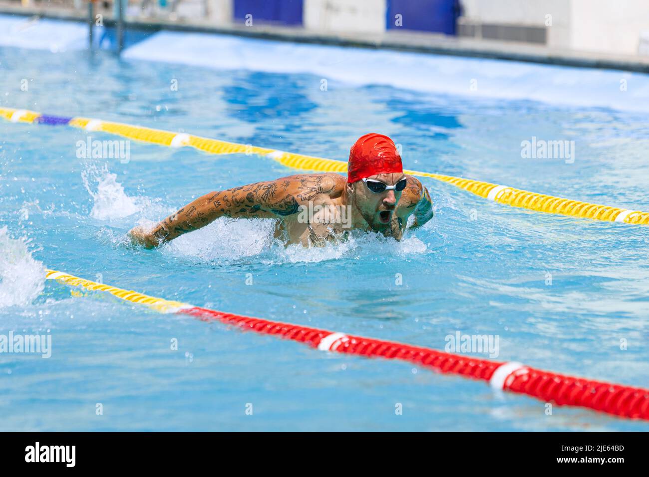 One athlete, male professional swimmer in goggles and red swimming cap ...