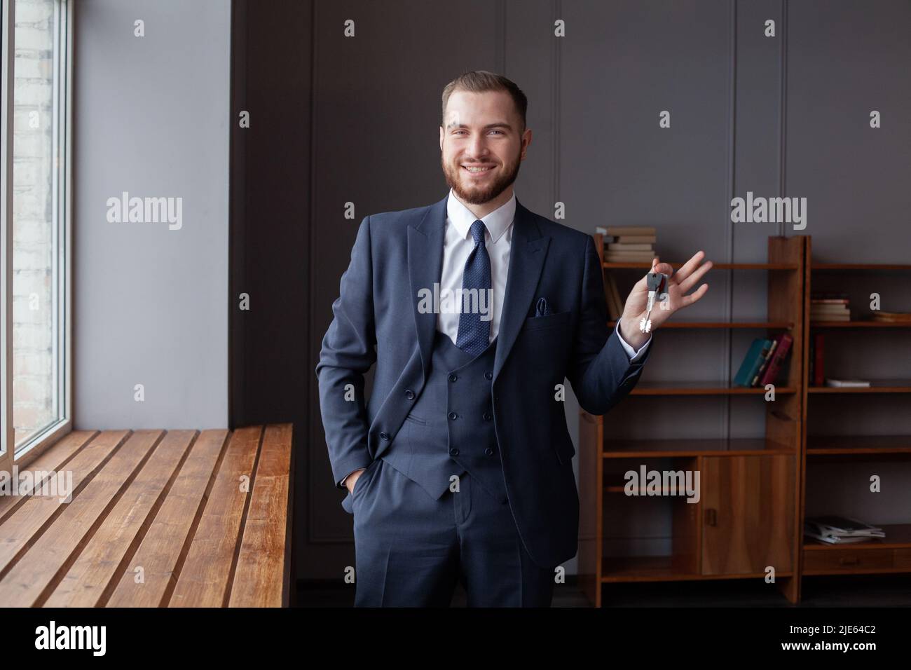 Happy successful businessman smiling and holding keys. Property, loan ...