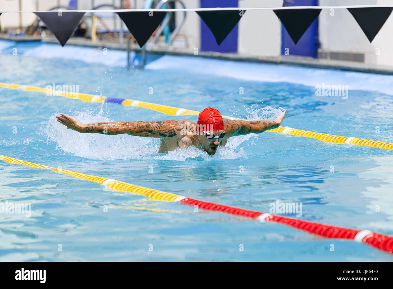 One athlete, male professional swimmer in goggles and red swimming cap ...