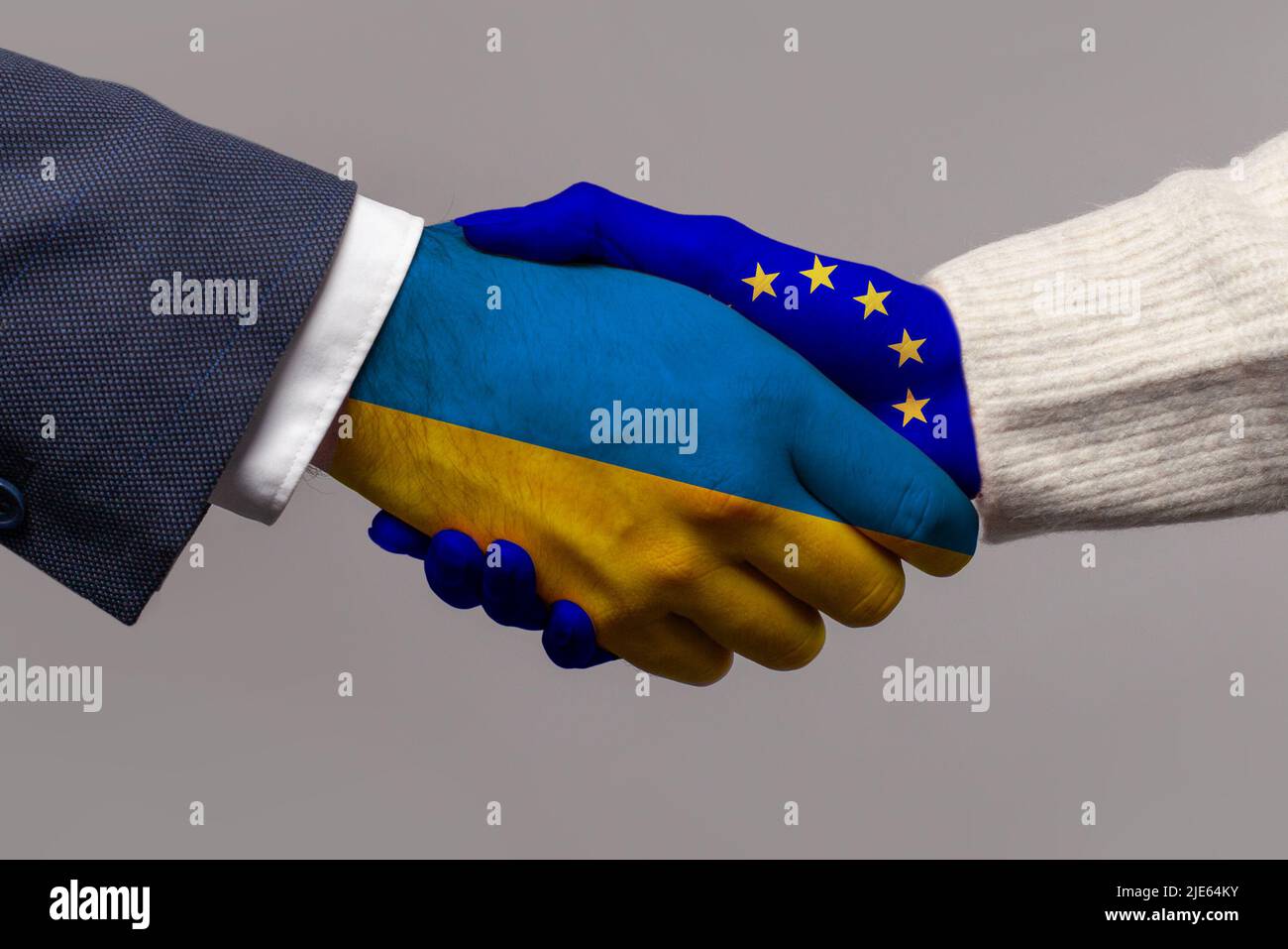 Ukraine and European Union flag, handshake closeup on grey background ...