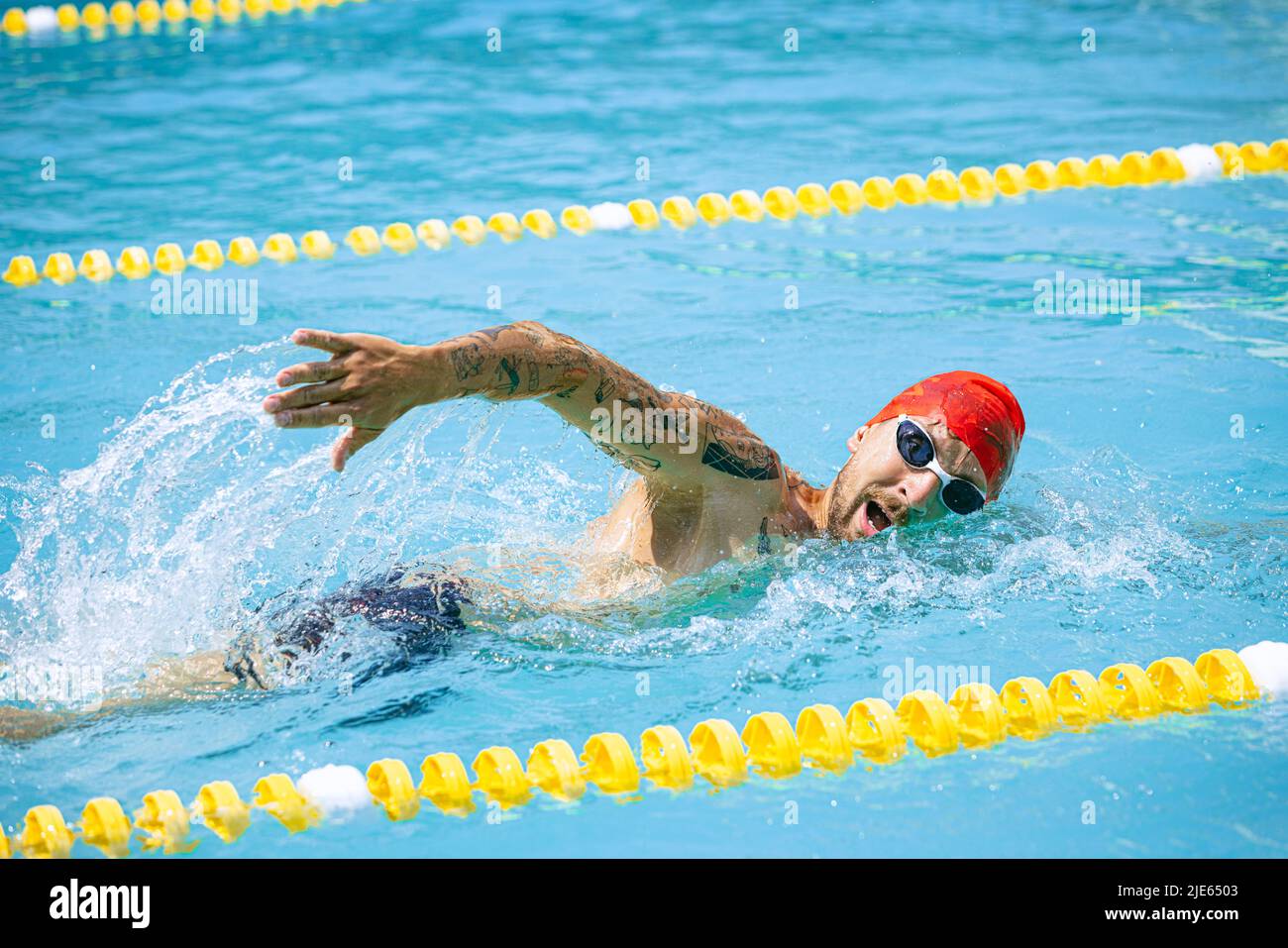 Live portrait of young sportive man, professional swimmer in goggles ...