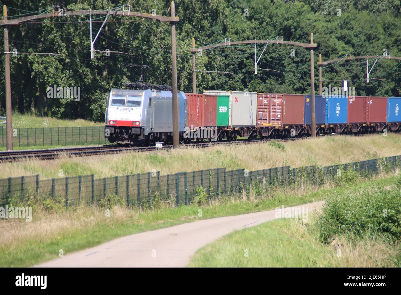 Traxx locomotive with container freight train on track close to ...