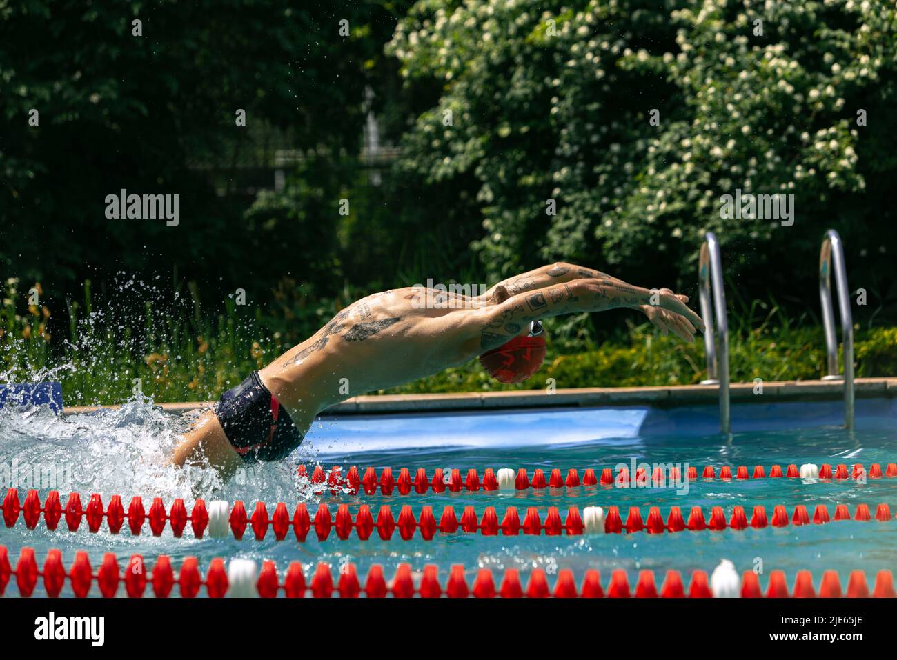 Live portrait of young sportive man, professional swimmer in goggles ...