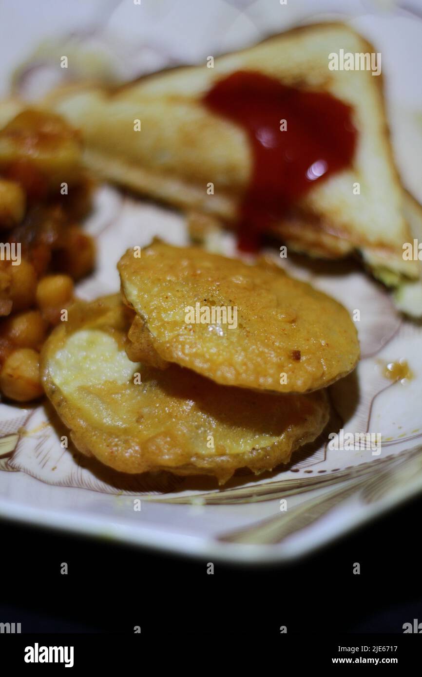 Desi Nashta breakfast Sandwich and pakora fries Vada Pav in the plate ...