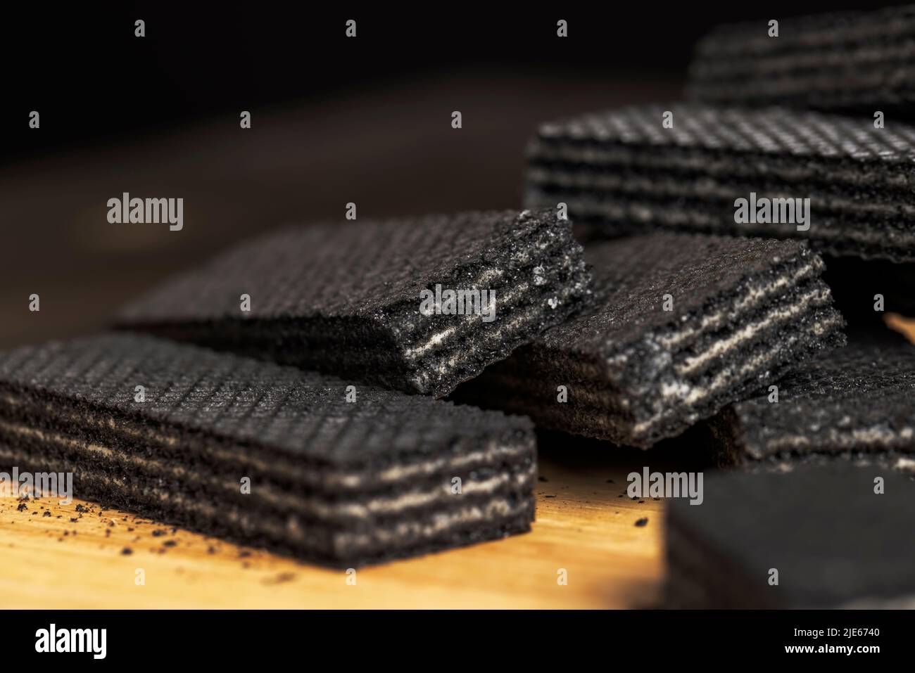 sweet dessert black waffles with creamy filling inside, laid out on a ...