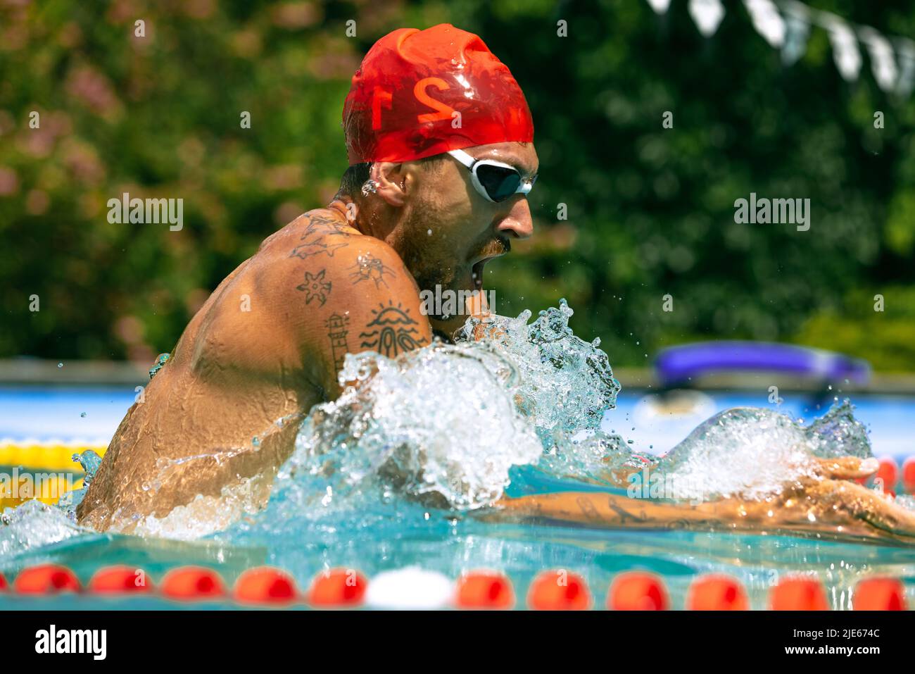 One muscular man, professional swimmer in goggles training at public ...