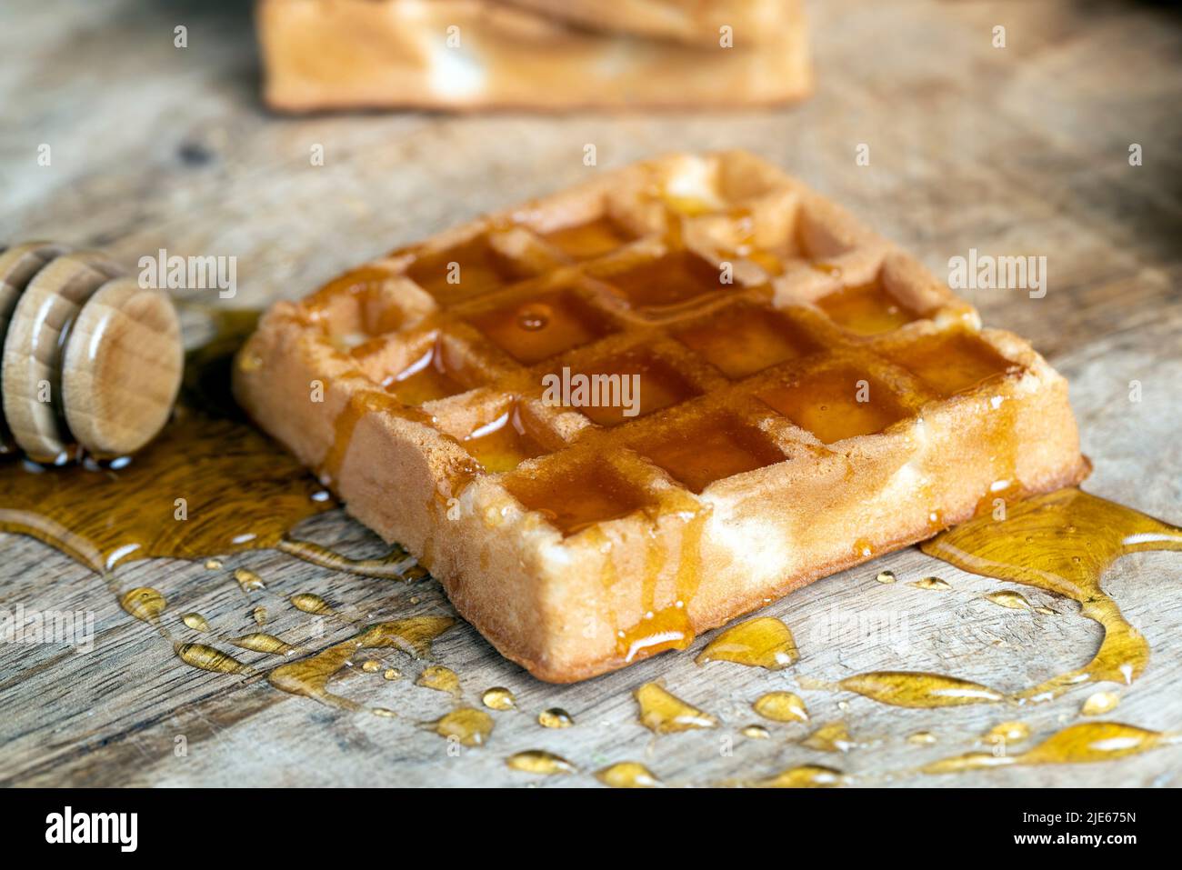 square sweet soft waffles in bee honey , a traditional European dessert ...