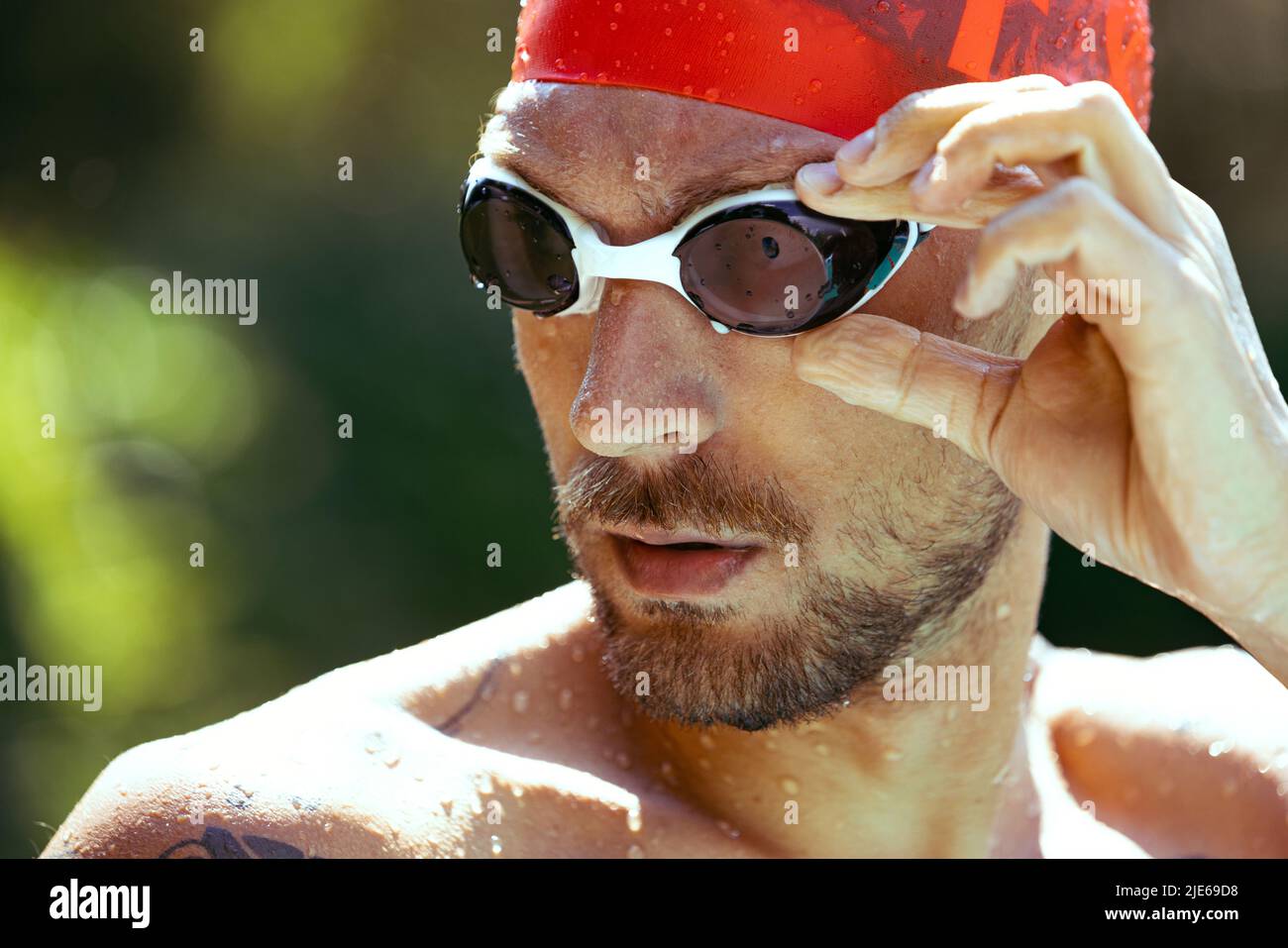Closeup young handsome man, professional swimmer in goggles and ...