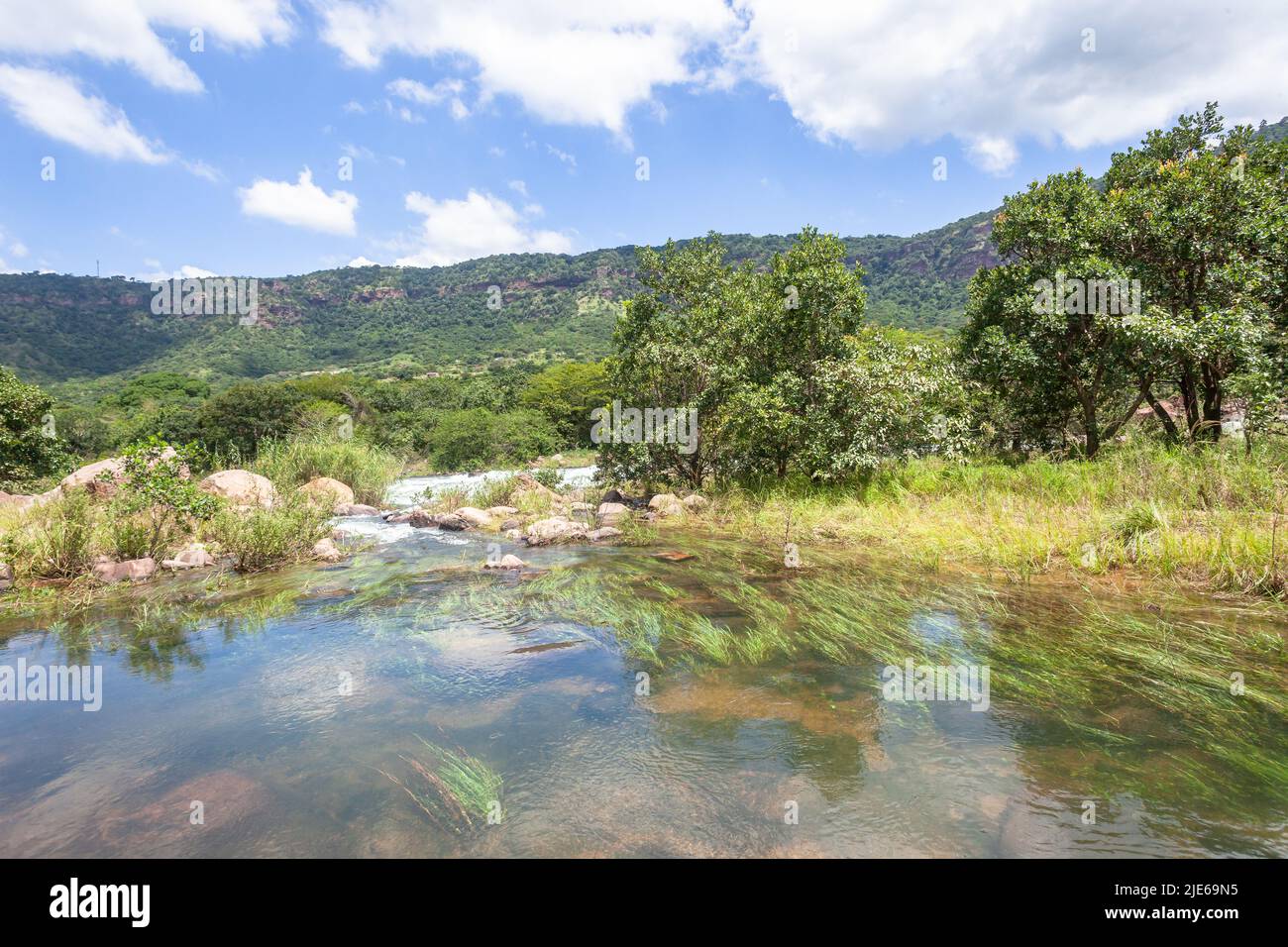 River small tributary of clean water flowing over rocky rapids summer ...