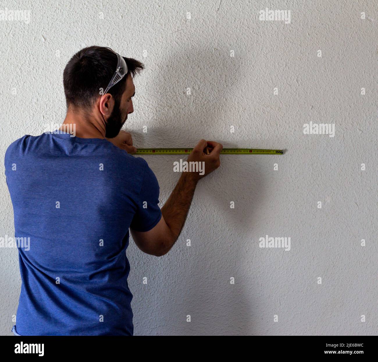 short-haired man with blue t-shirt works on construction Stock Photo ...