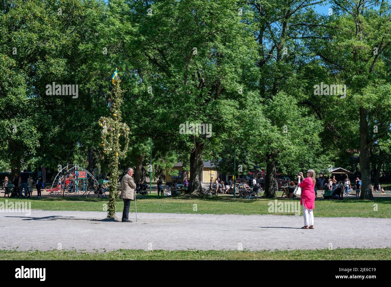 Woman takes a photograph of the traditional Maypole on an unusually ...