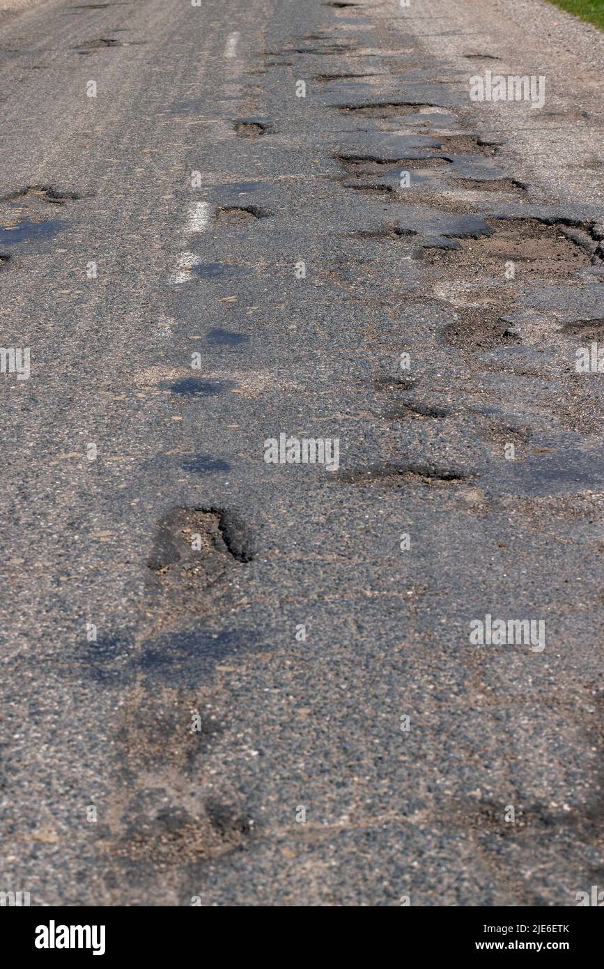 poor paved road with a lot of holes and potholes, poor transport ...