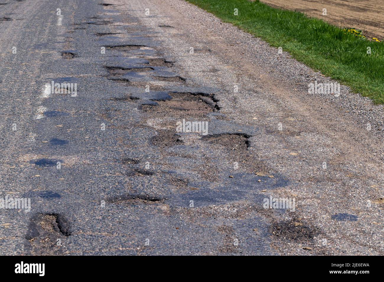 poor paved road with a lot of holes and potholes, poor transport ...