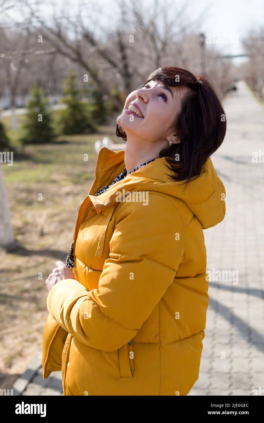 Woman in jacket enjoying spring weather, walking after work Stock Photo ...