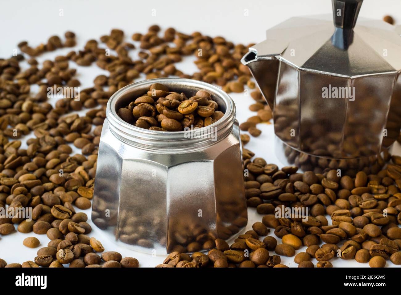 Traditional italian metal coffee maker with coffee beans on white ...