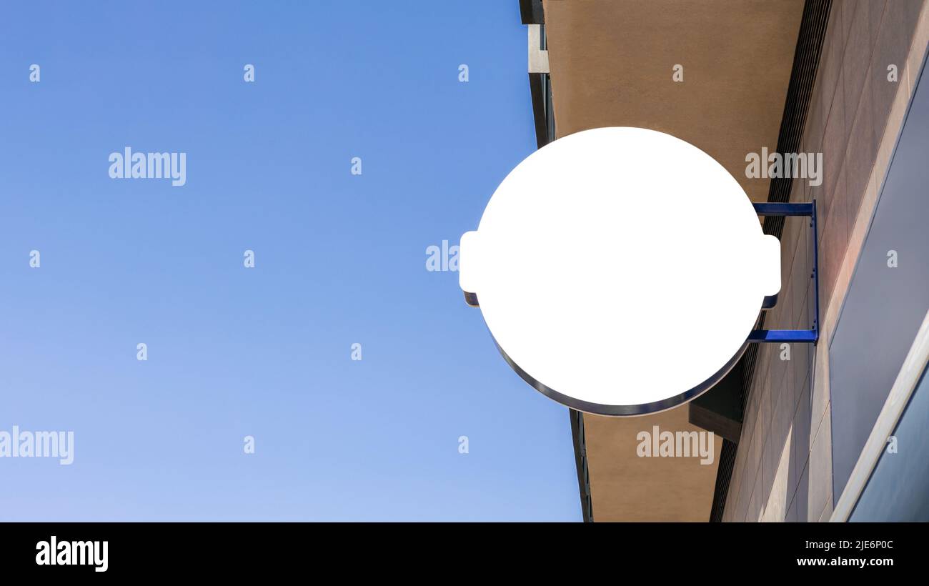 Blank circle sign mockup in the urban environment, on the facade, empty ...