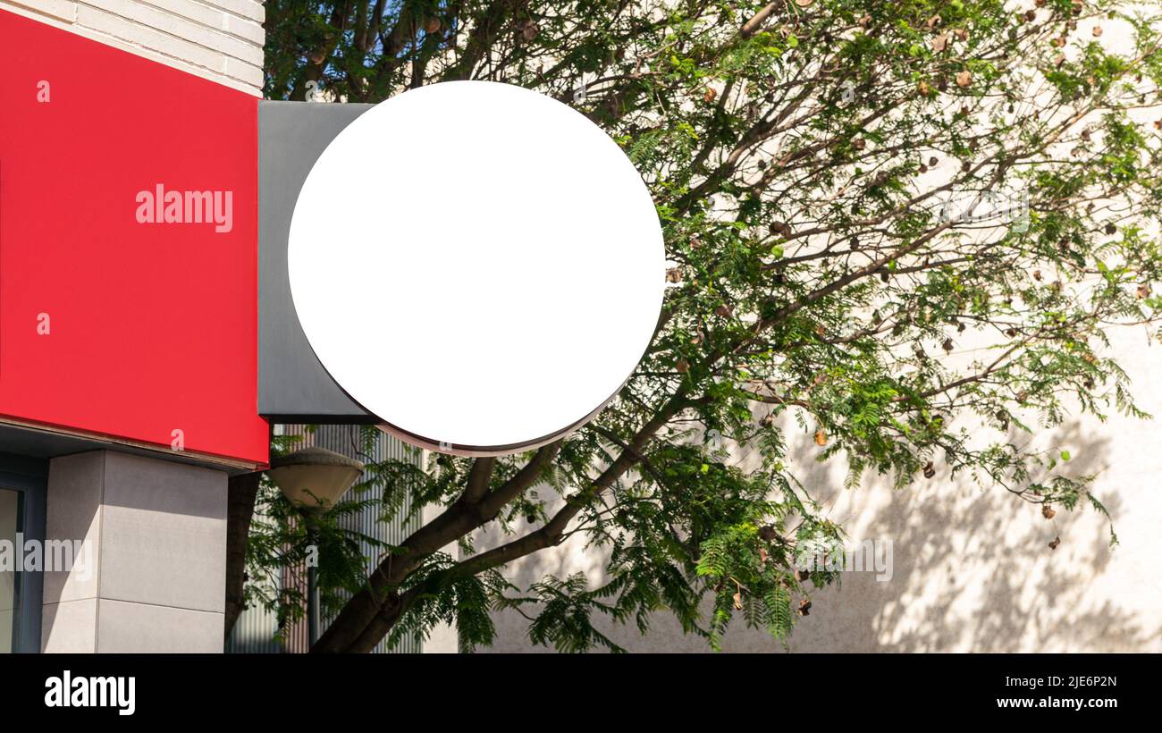 Blank circle sign mockup in the urban environment, on the facade, empty ...